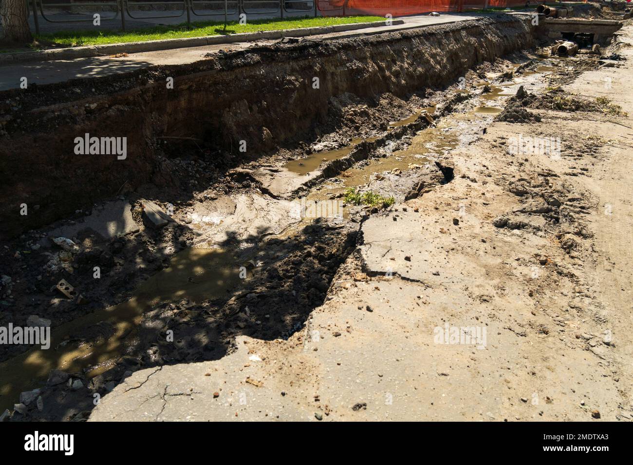 Hole in the asphalt road repair, replacement of underground water ...