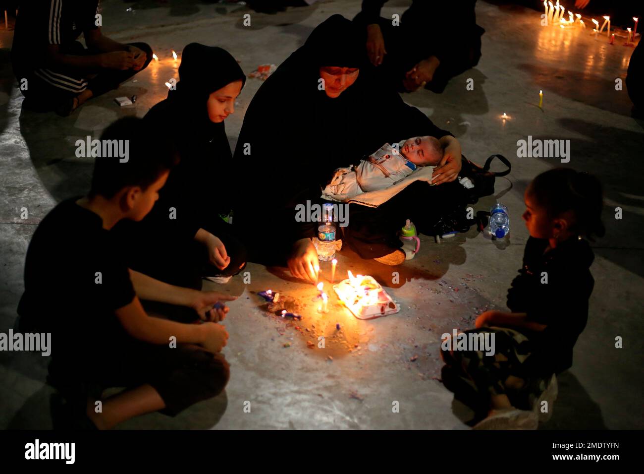 Shiite faithful pilgrims light candles outside the holy shrine of Imam ...