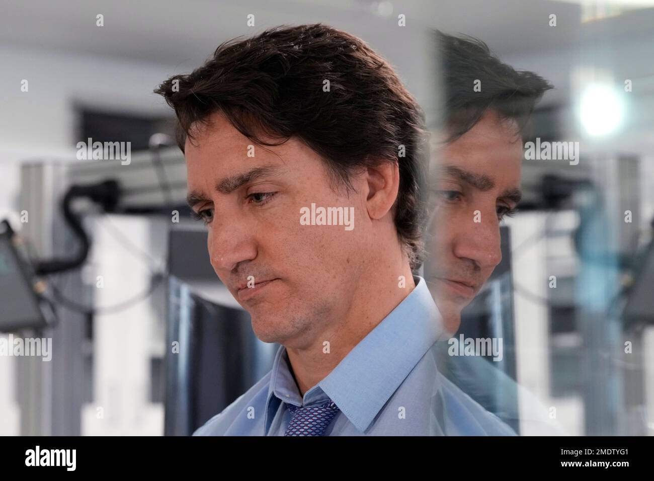 Prime Minister Justin Trudeau is reflected in a glass door as he ...
