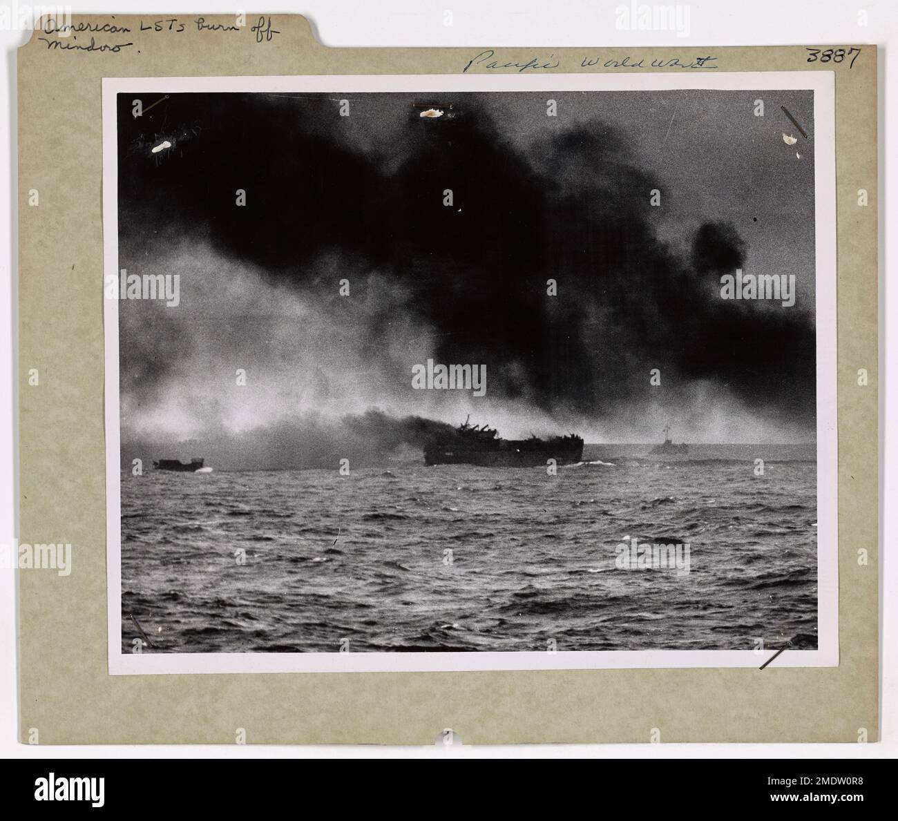 A Coast Guard-manned LST captures the moment after a Japanese air raid ...