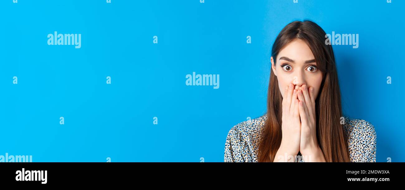 People emotions concept. Shocked young woman face, covering mouth with ...