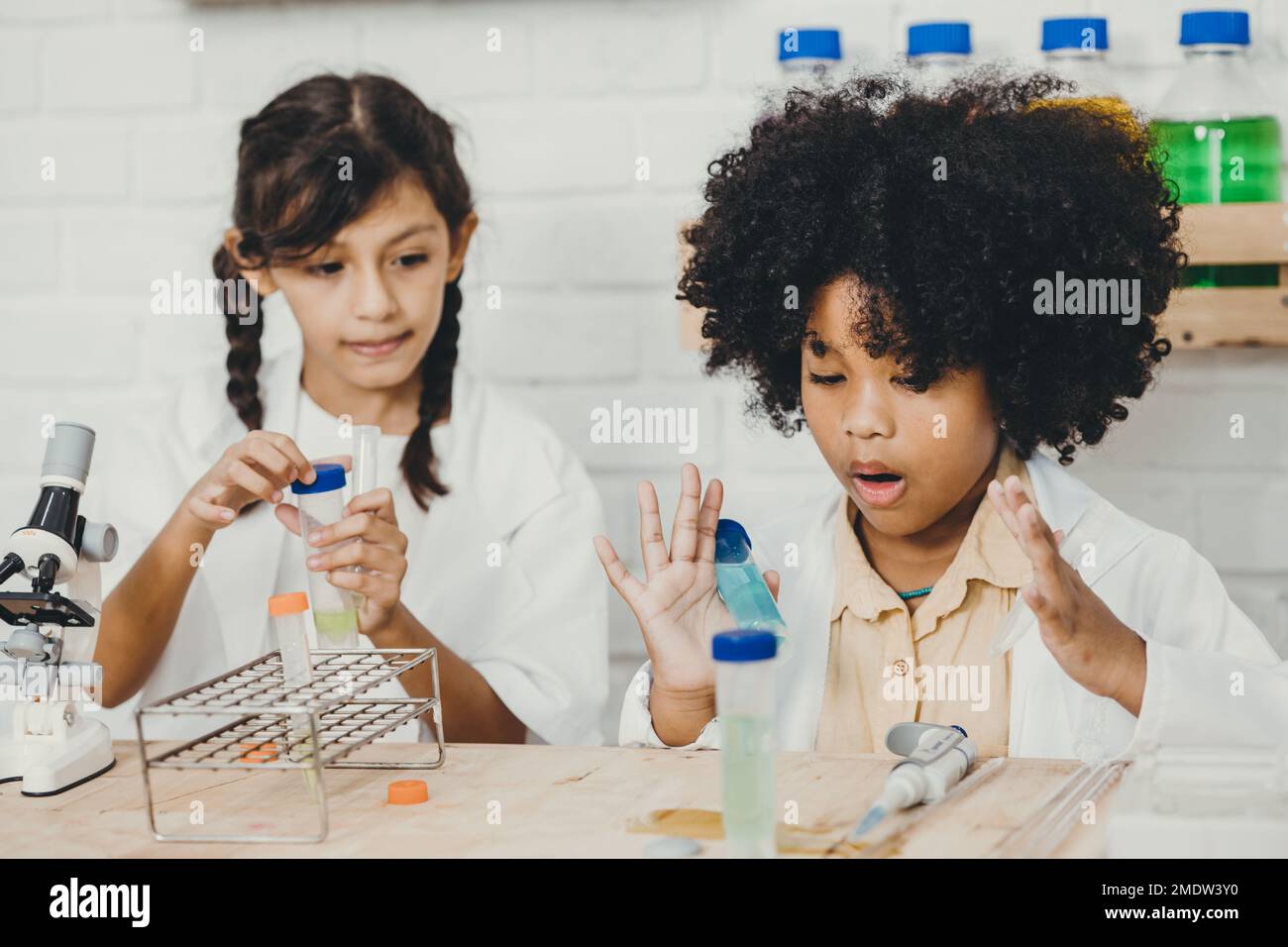 Young children playing exciting with chemistry science kits in school ...