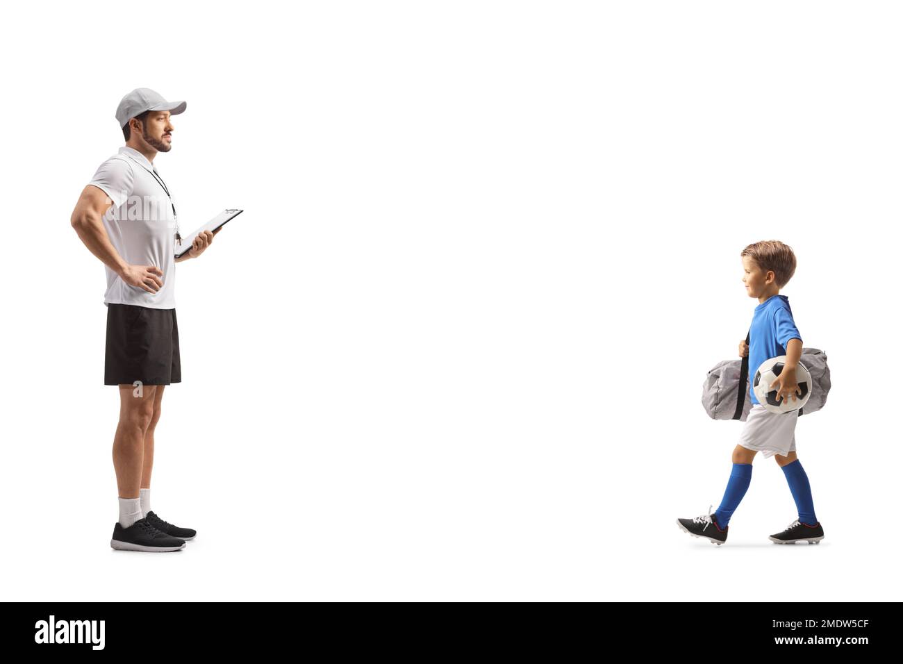 Boy carrying a football and walking towards a sports coach isolated on ...