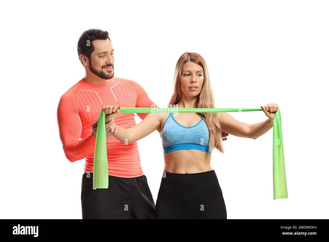 Fitness trainer showing an exercise to a woman with an elastic band ...