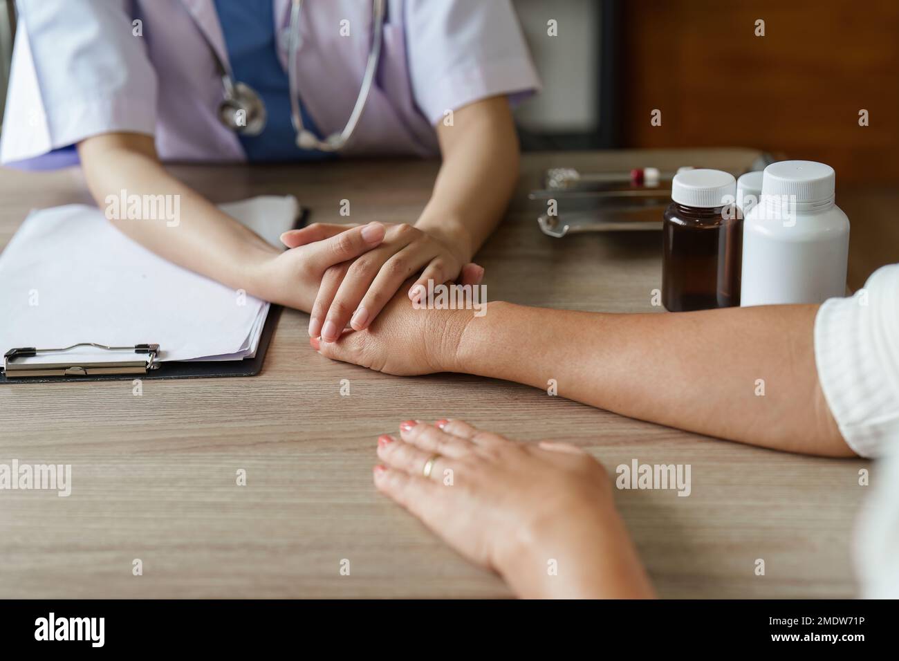 Doctor giving hope. Close up of doctor holding hand of elderly lady ...