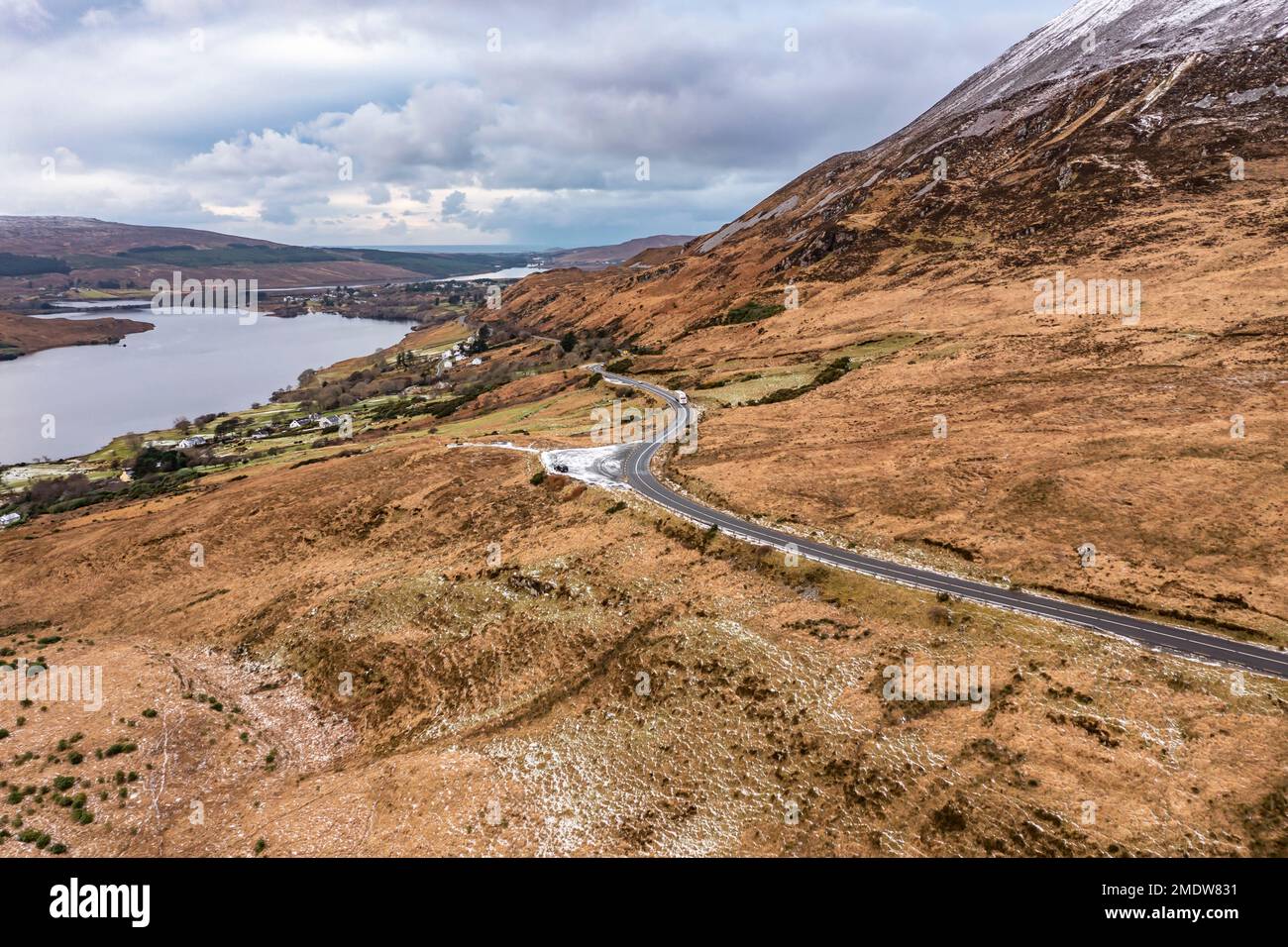 The R251 next to the snow covered Mount Errigal, the highest mountain ...