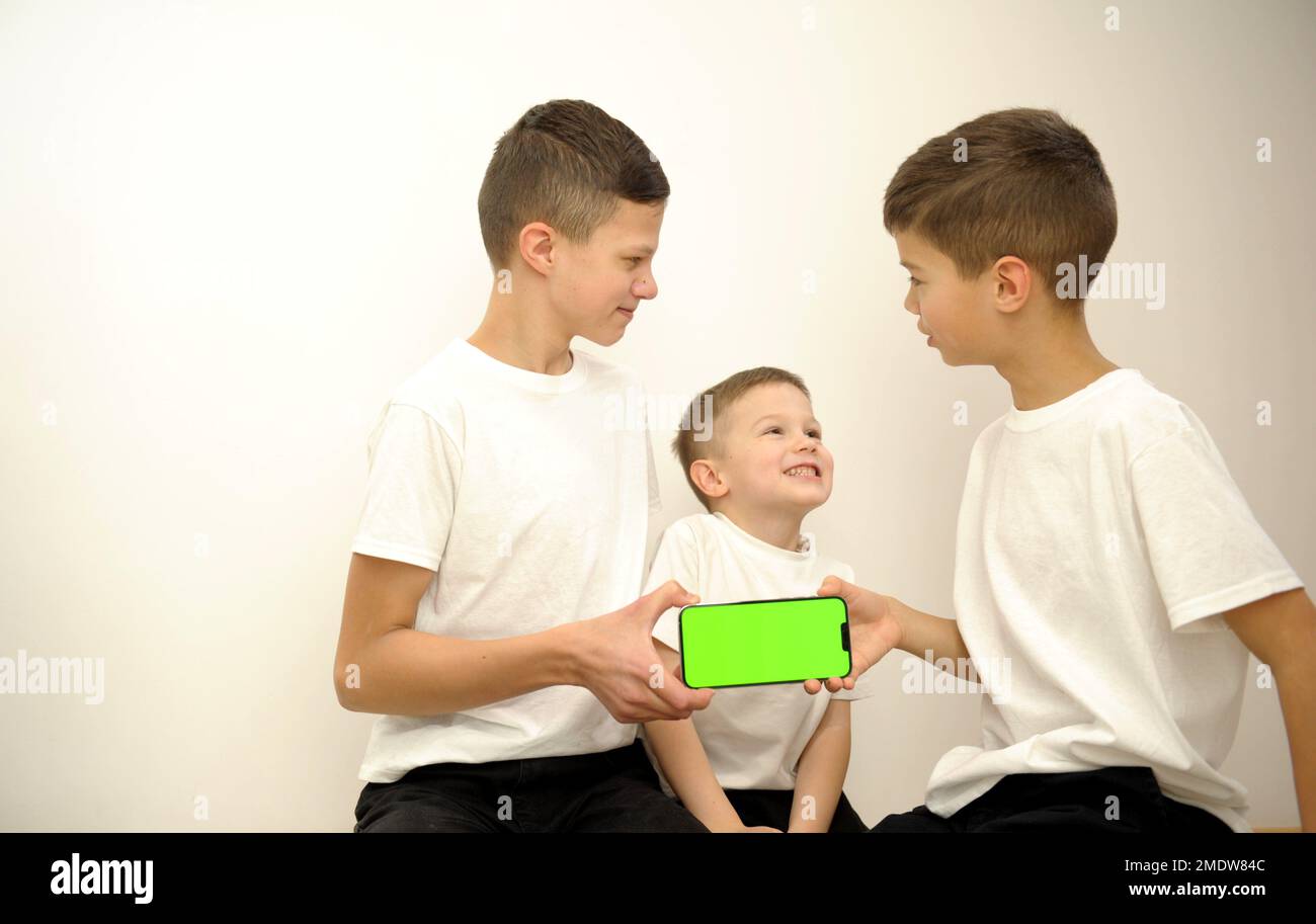 family photo three siblings are talking on a white background holding a ...