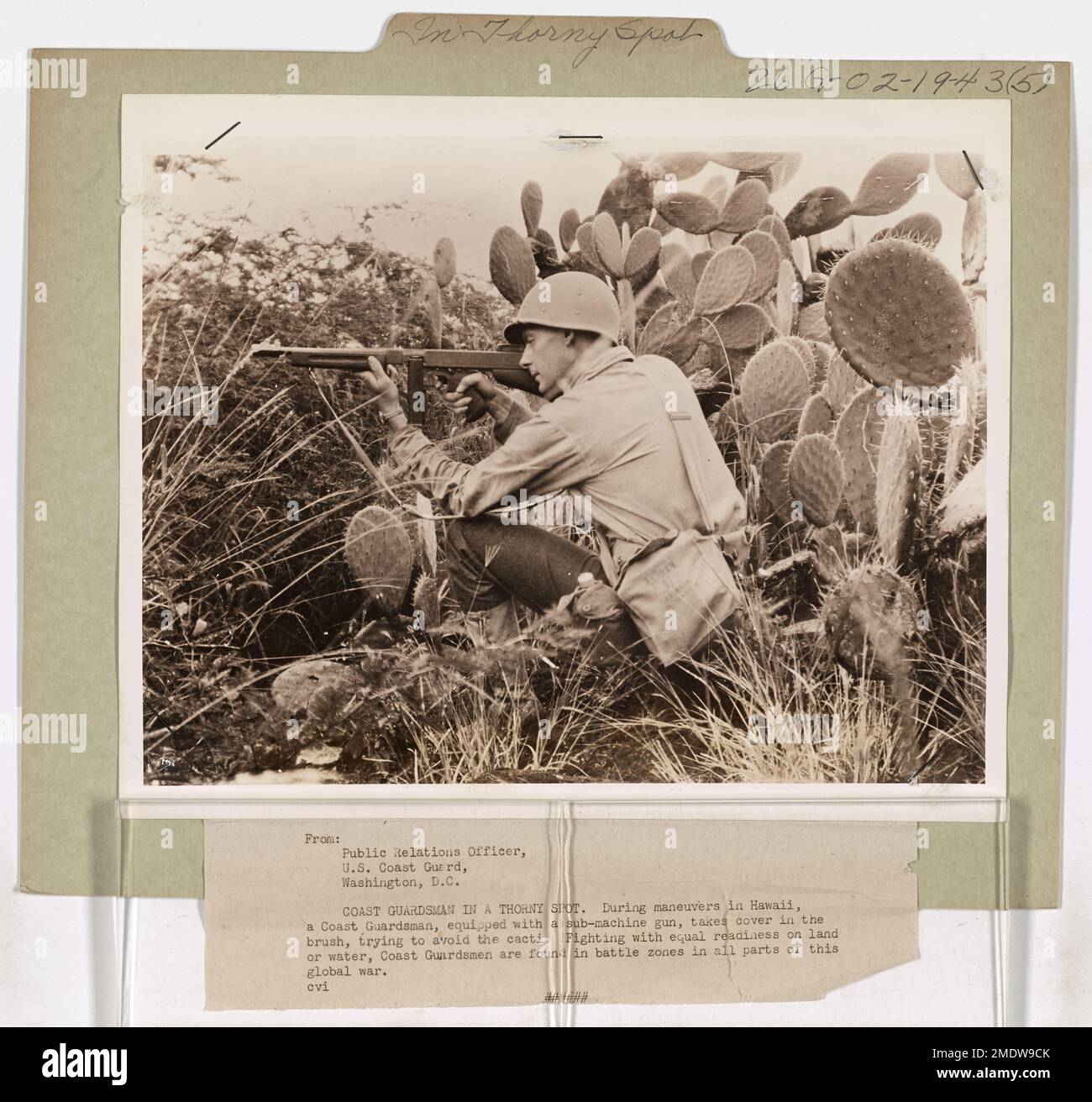 A Coast Guardsman, equipped with a sub-machine gun, takes cover in ...