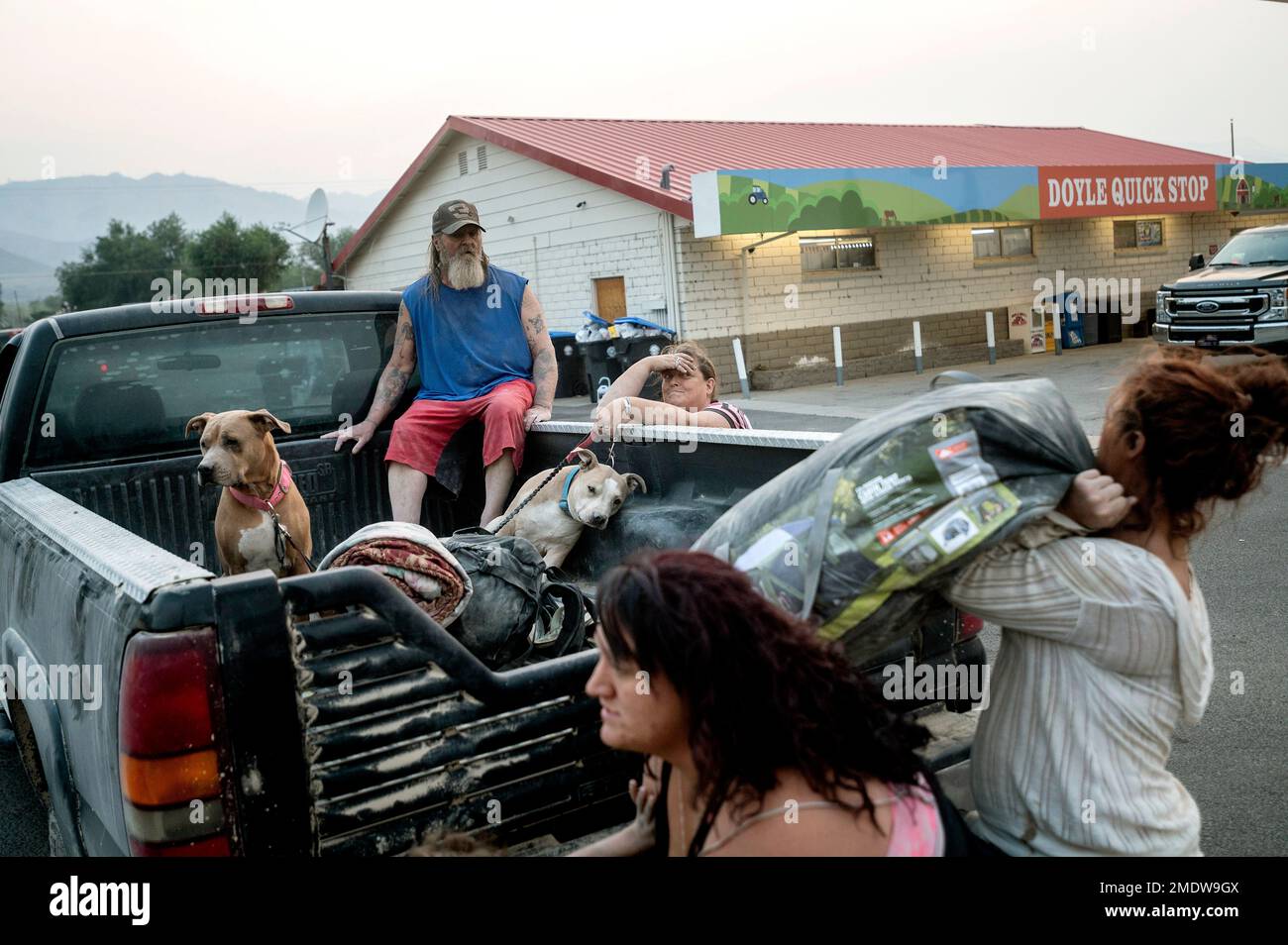 Susanville residents sit in the back of a pick-up truck while stranded ...
