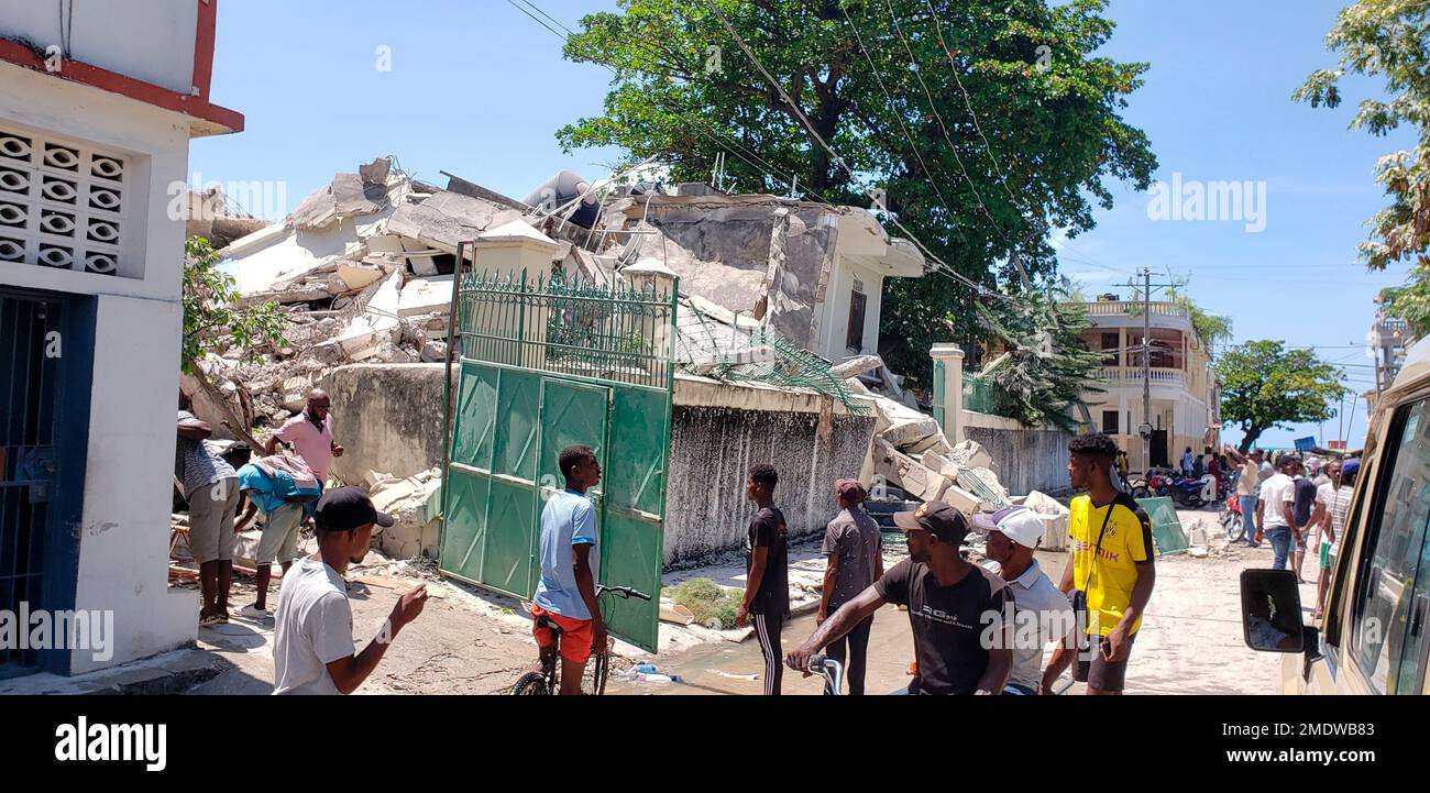 People stand outside the residence of the Catholic bishop after it was ...