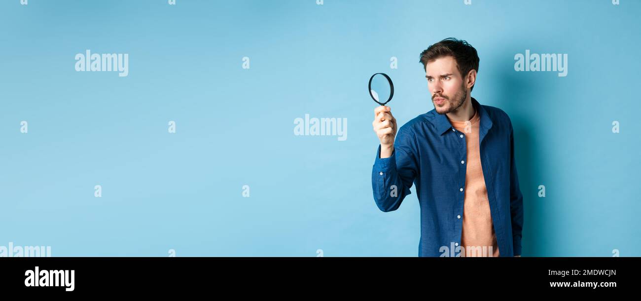 Serious man investigating or searching for something, look through ...