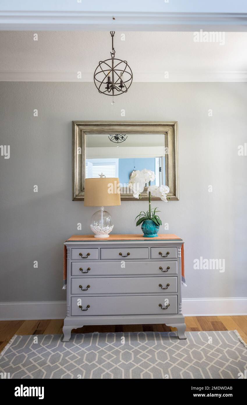 An open large and wide interior front door hallway foyer with a hanging ...