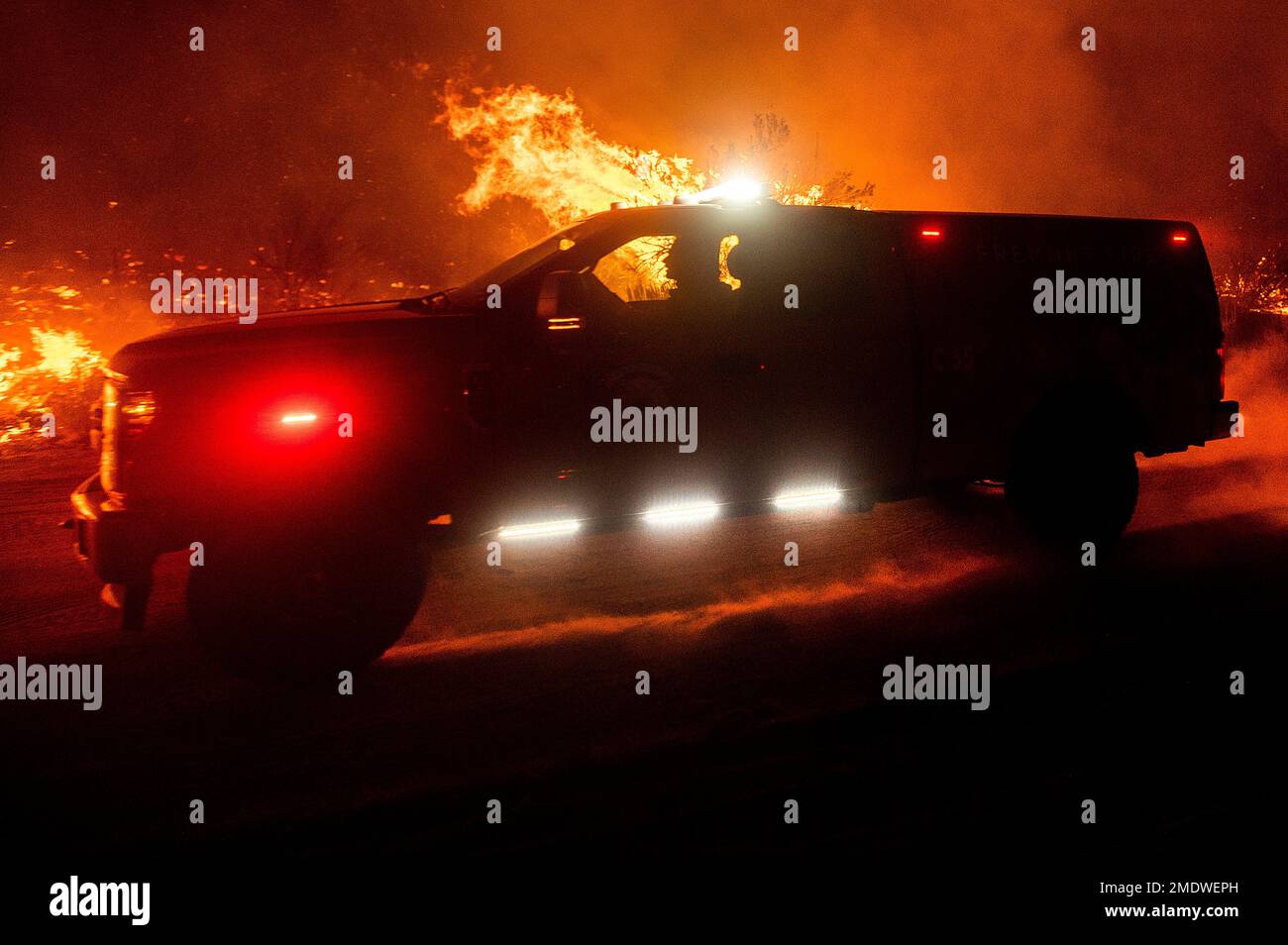 Firefighters drive along Highway 395 south of Janesville in Lassen ...