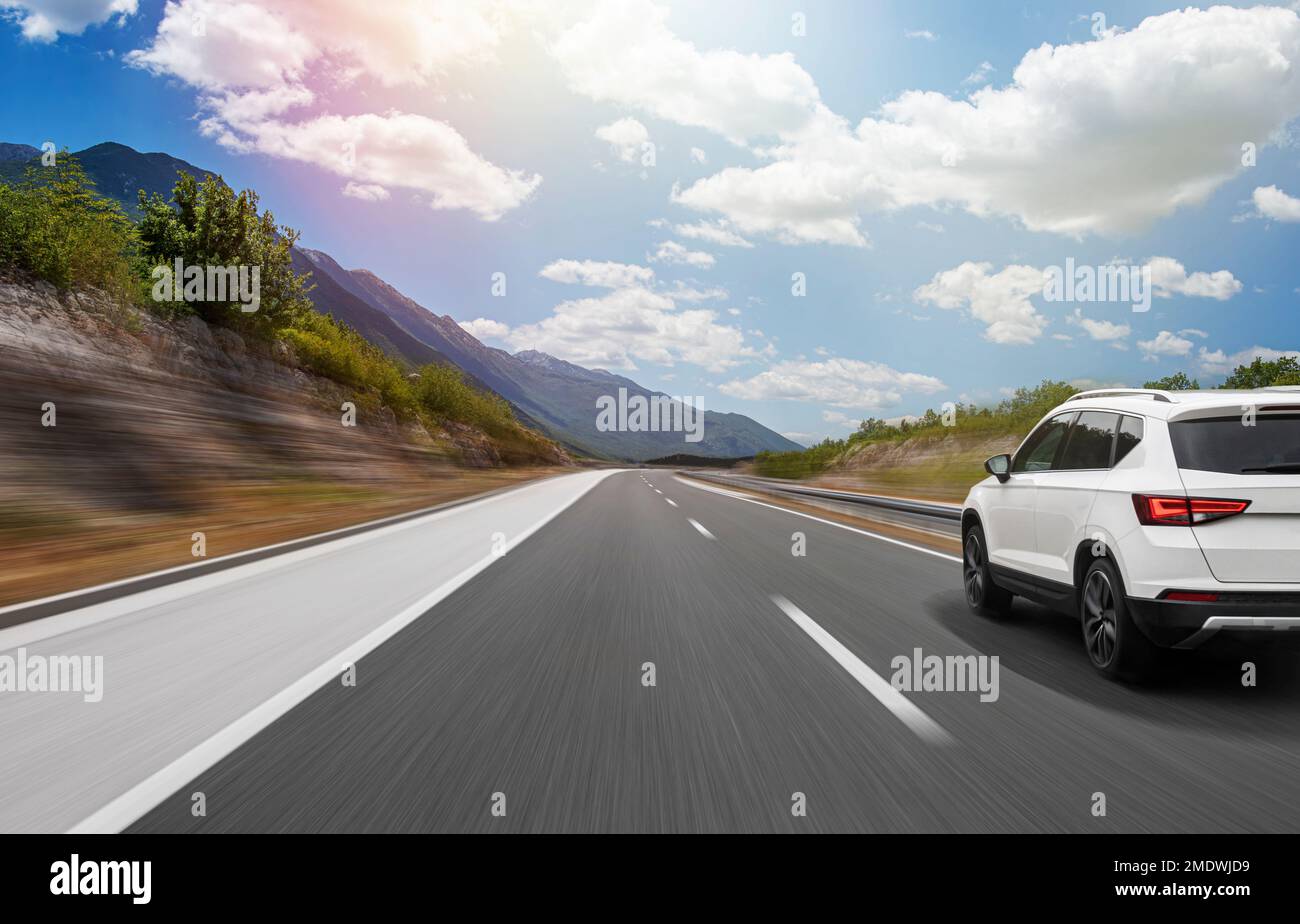 A white car is driving along the road Stock Photo - Alamy