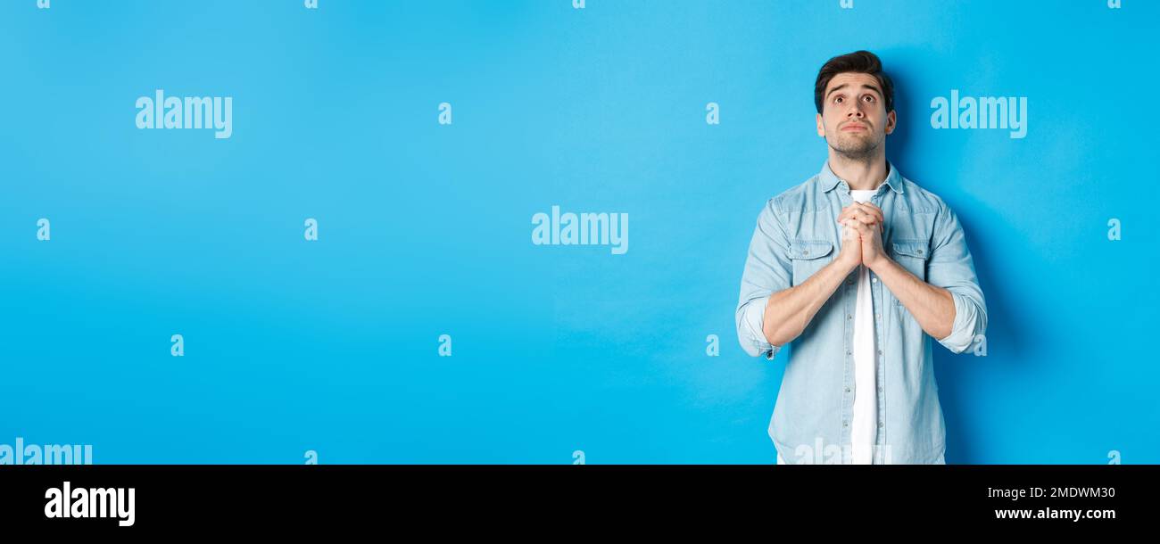 Hopeful young man looking up and praying God, begging for help ...