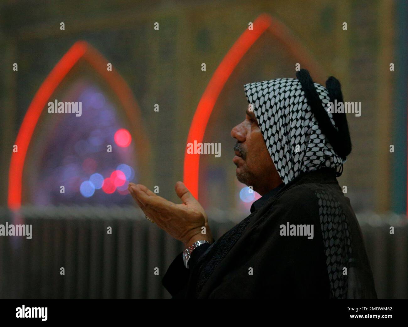 A Shiite man prays inside the holy shrine of Imam Ali, the son-in-law ...