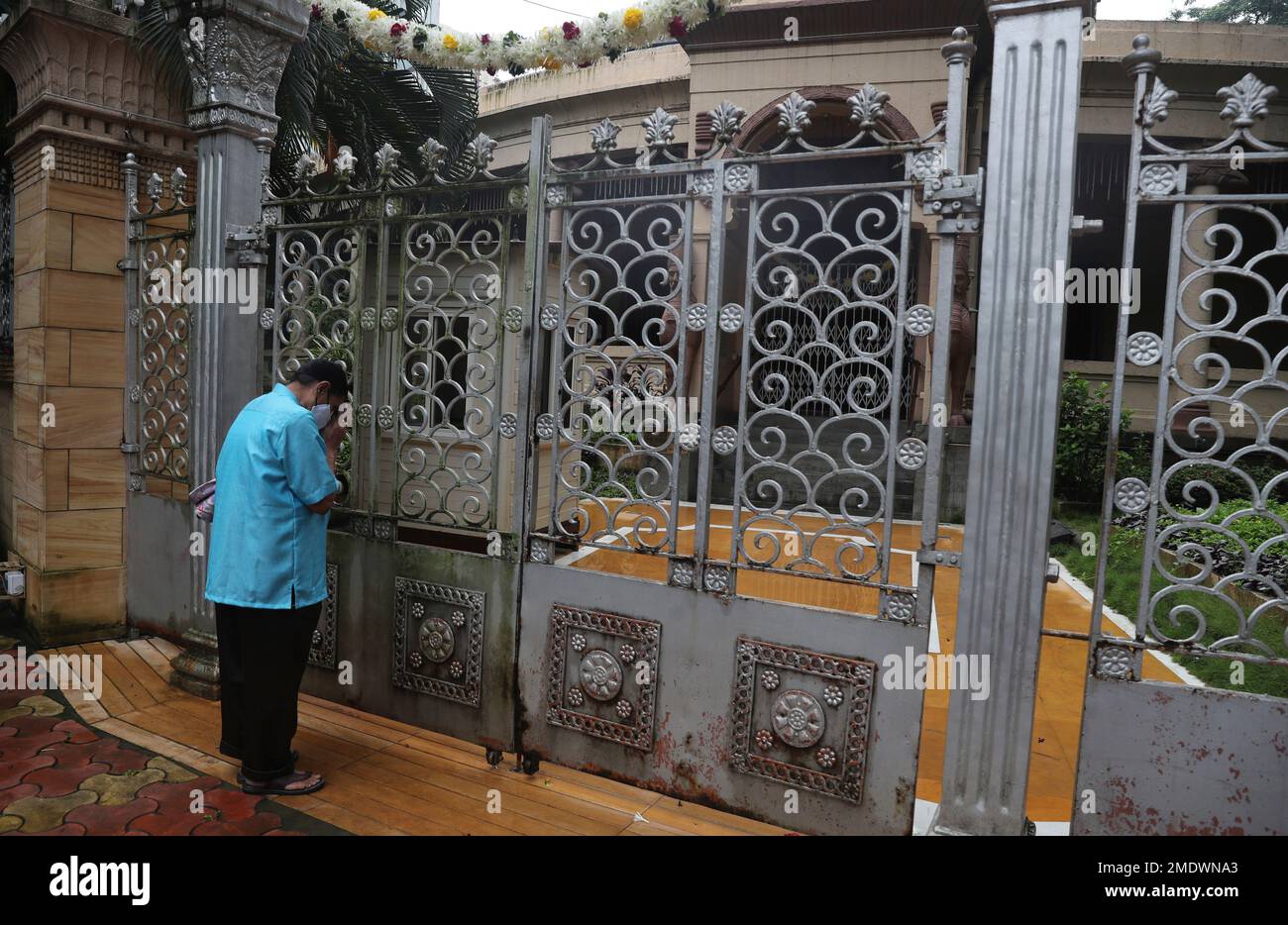 A Parsi woman prays at the gate of fire temple at a Parsi colony on ...