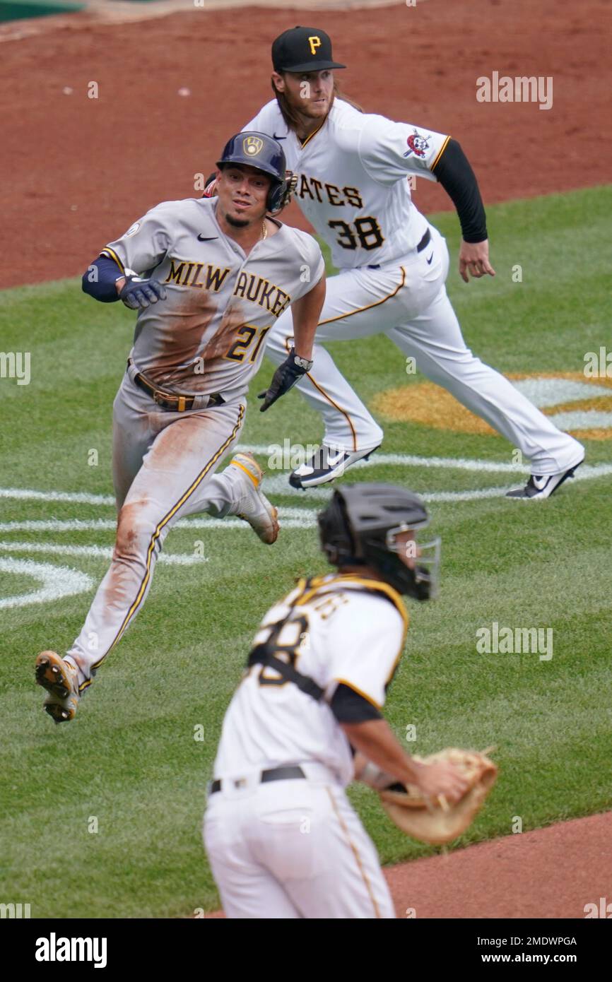 Milwaukee Brewers' Willy Adames, center, takes a wide turn to home as ...