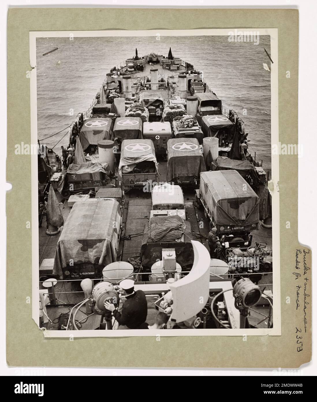 A Coast Guard-manned LST transports trucks, jeeps, and ambulances ...