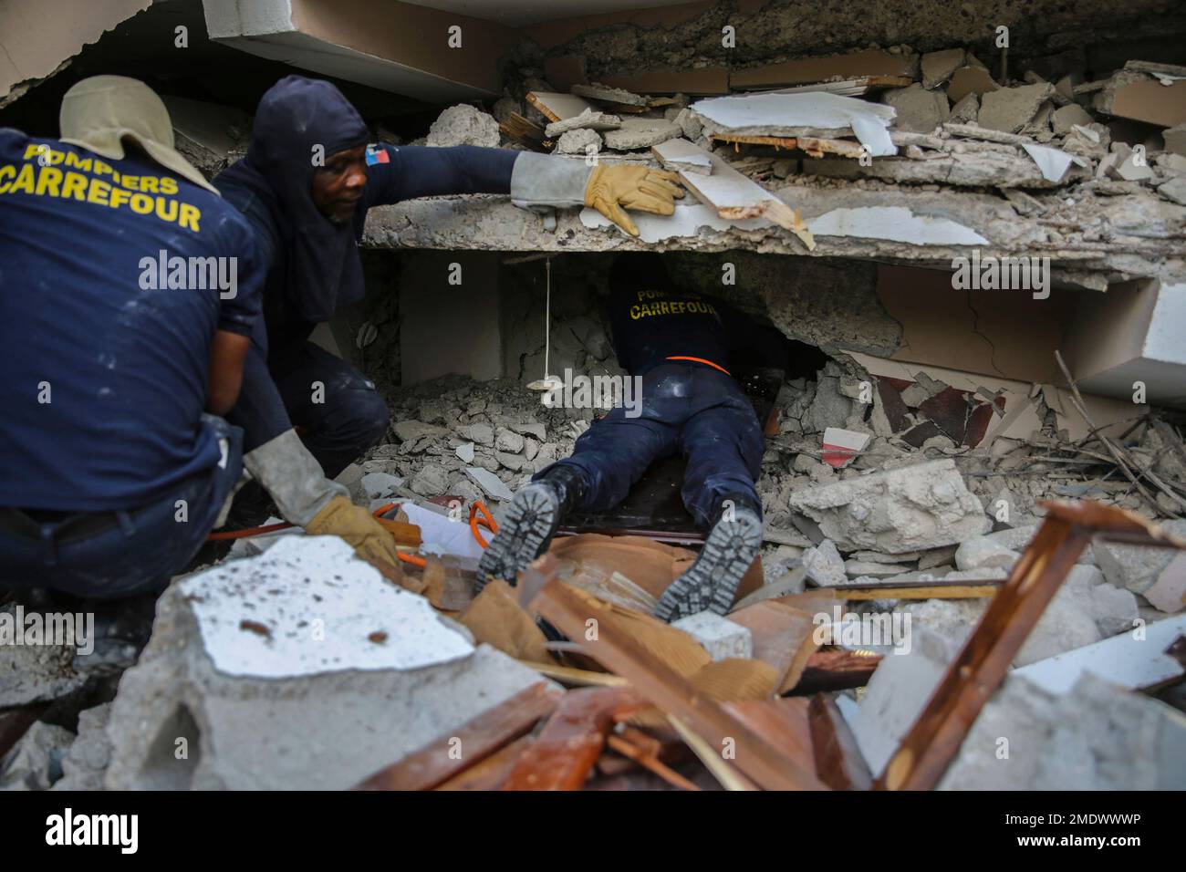 Firefighters search for survivors inside a collapsed building, after ...