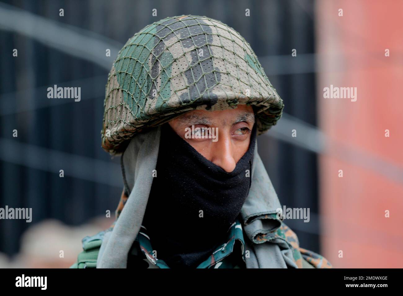 An Indian paramilitary soldier stands guard on a deserted street on ...
