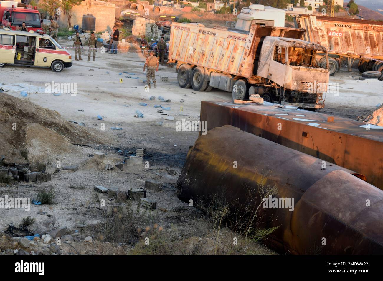 Rescue workers and Lebanese soldiers gather at the scene where a fuel ...