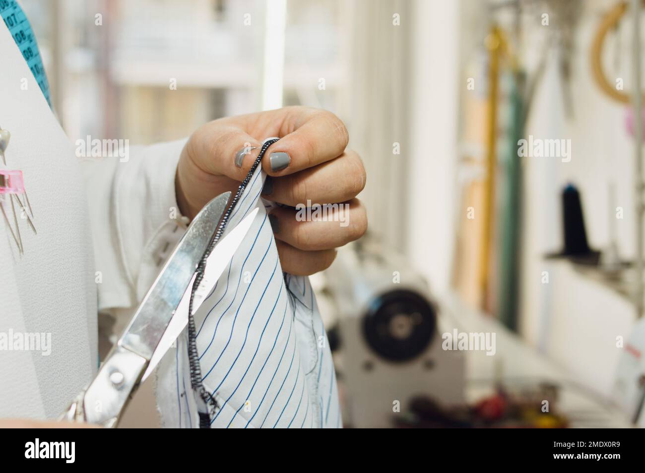 close-up of female hands cutting the edge of the fabric with the ...