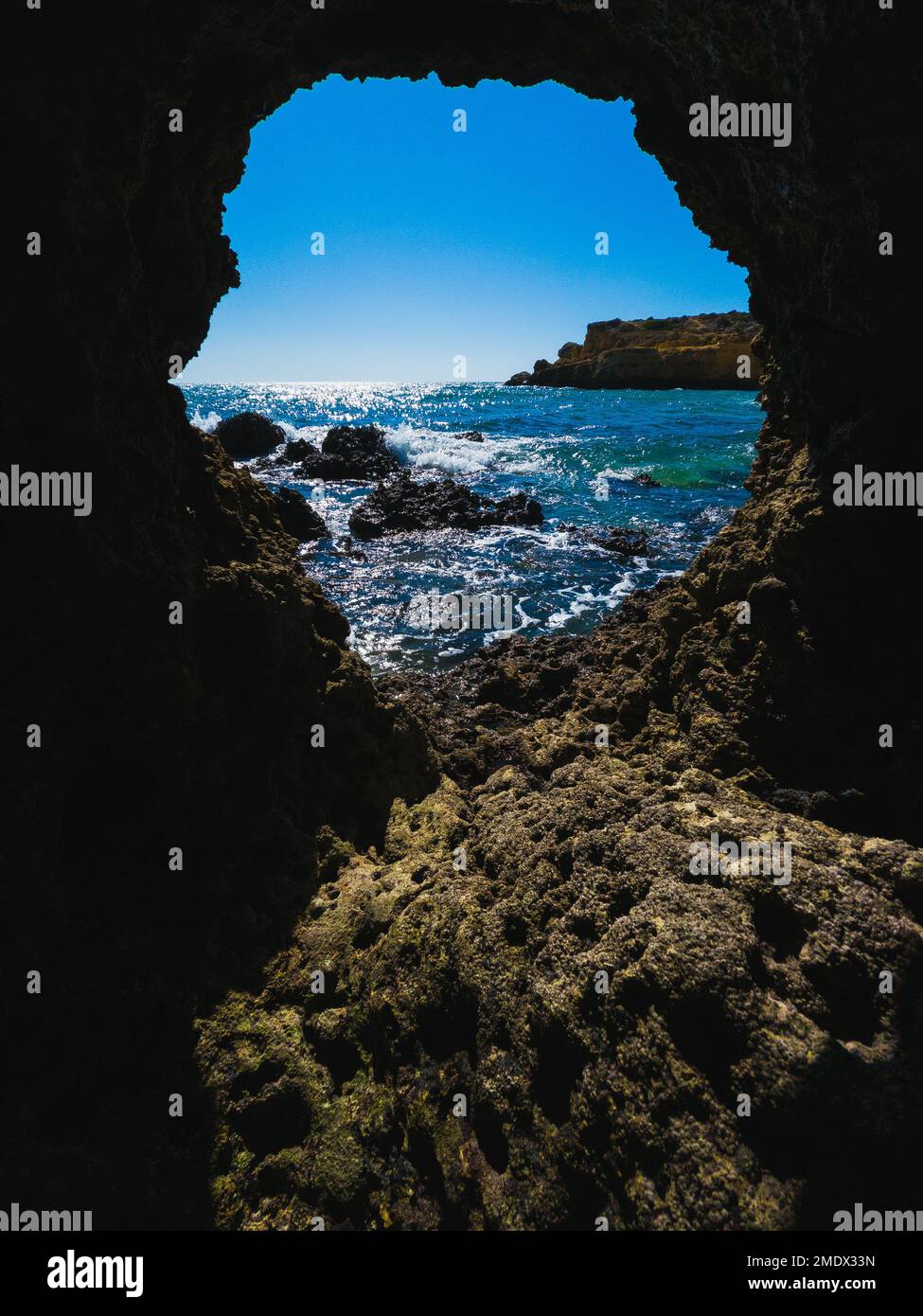 A vertical shot of a beautiful seascape seen from a cave located on the ...