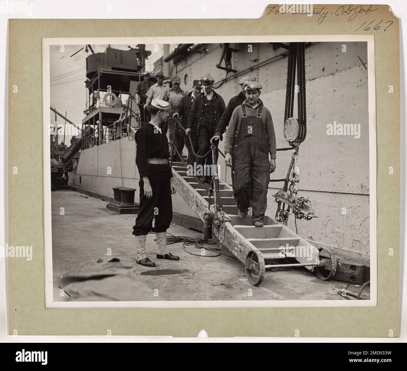 A Coast Guardsman stands watch over an ammunition ship after workers ...