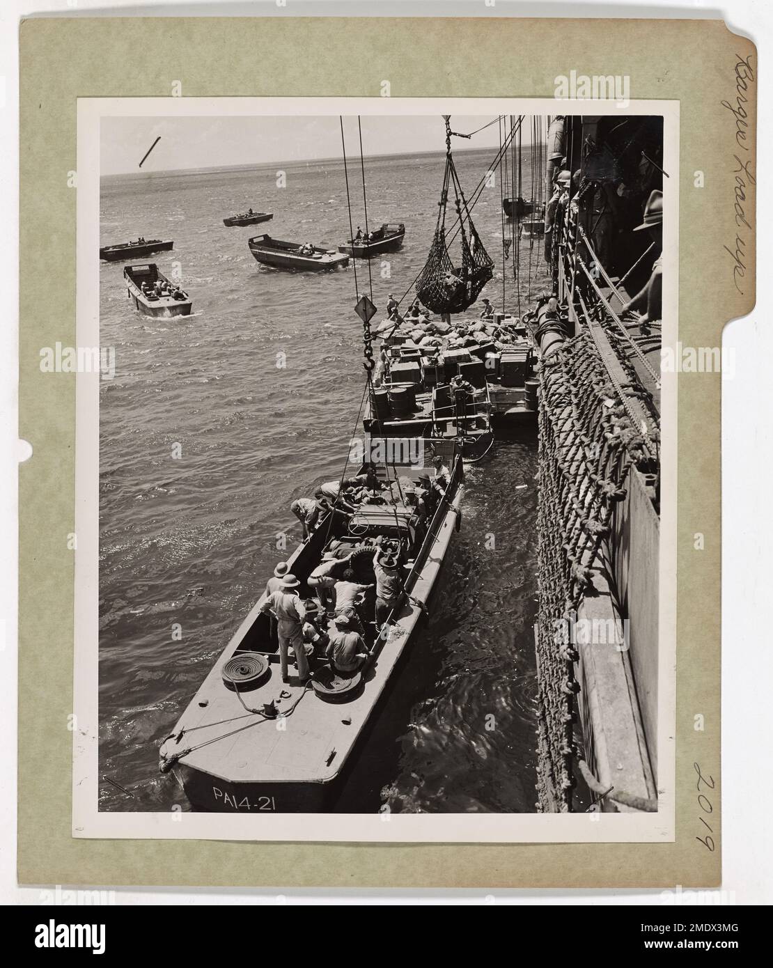 Coast Guard-manned landing craft load mechanized equipment and supplies ...