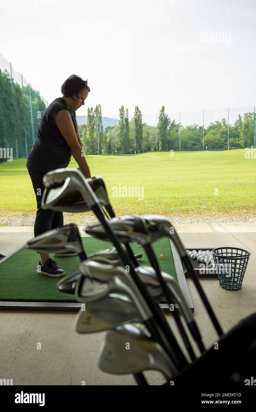 Golfer Practice in Driving Range and a Golf Bag with Golf Clubs in ...