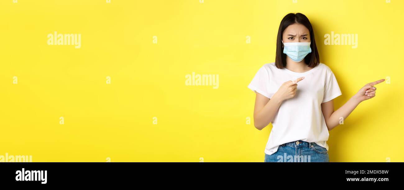 Covid-19, pandemic and social distancing concept. Disappointed asian ...