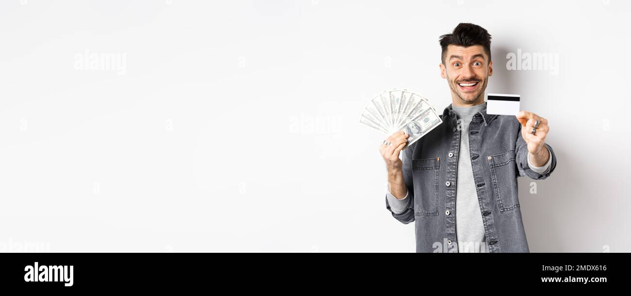 Image of handsome guy holding dollar bills but suggesting use plastic ...