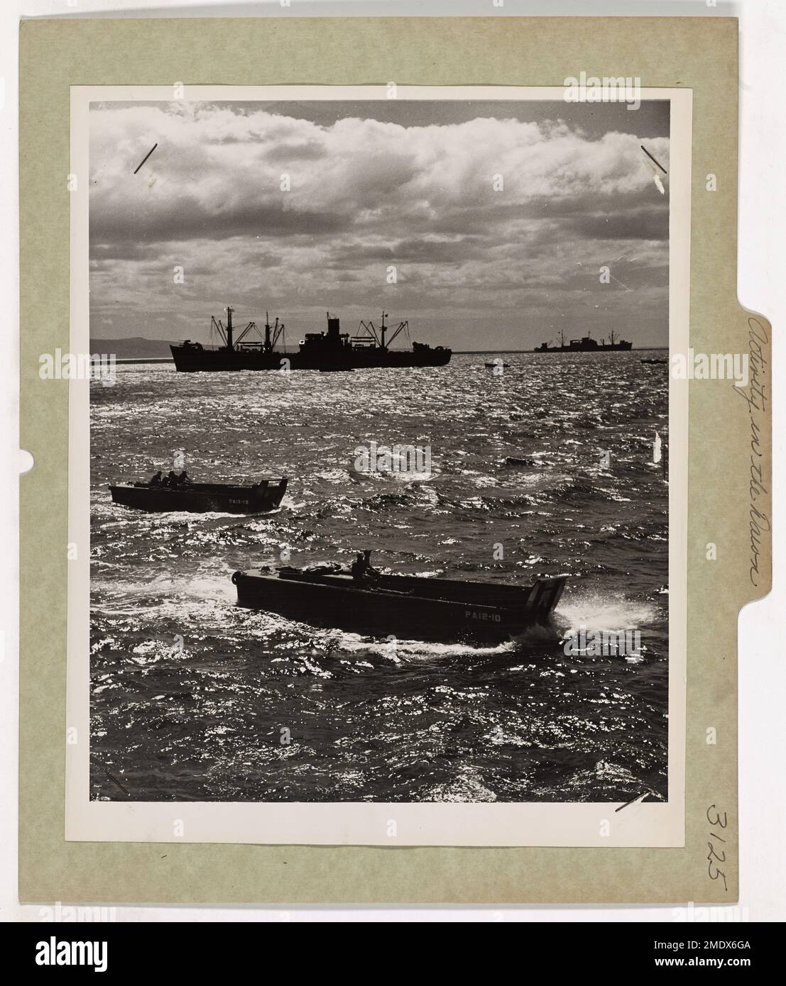 At dawn over the South Pacific, Coast Guardsmen operate landing barges ...