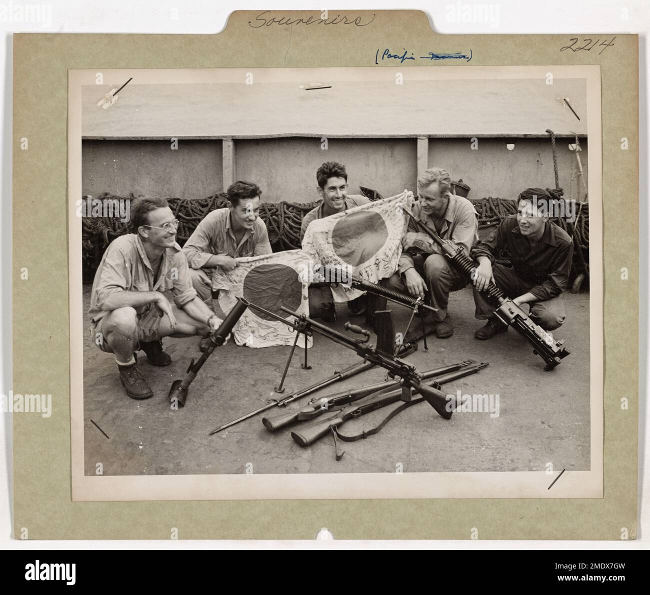 This image shows five Coast Guardsmen displaying Japanese trophies ...