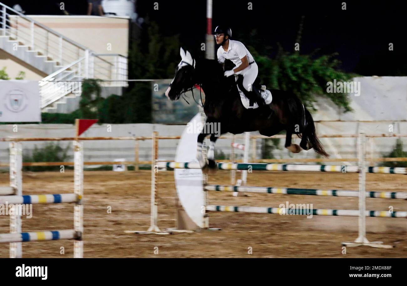 A Palestinian youth rider jumps barriers during a local horse jumping ...