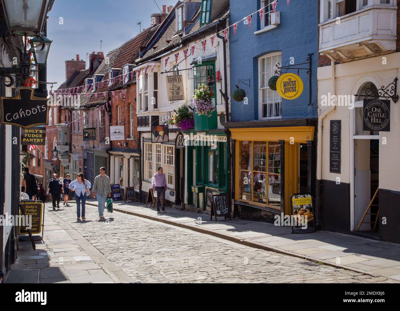Quaint shops line a steep cobbled road known as Steep Hill in Lincoln ...