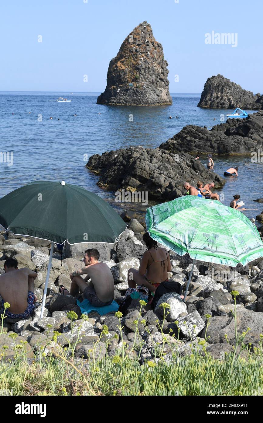 People enjoy time at the beach in Aci Trezza, near Catania, Sicily ...