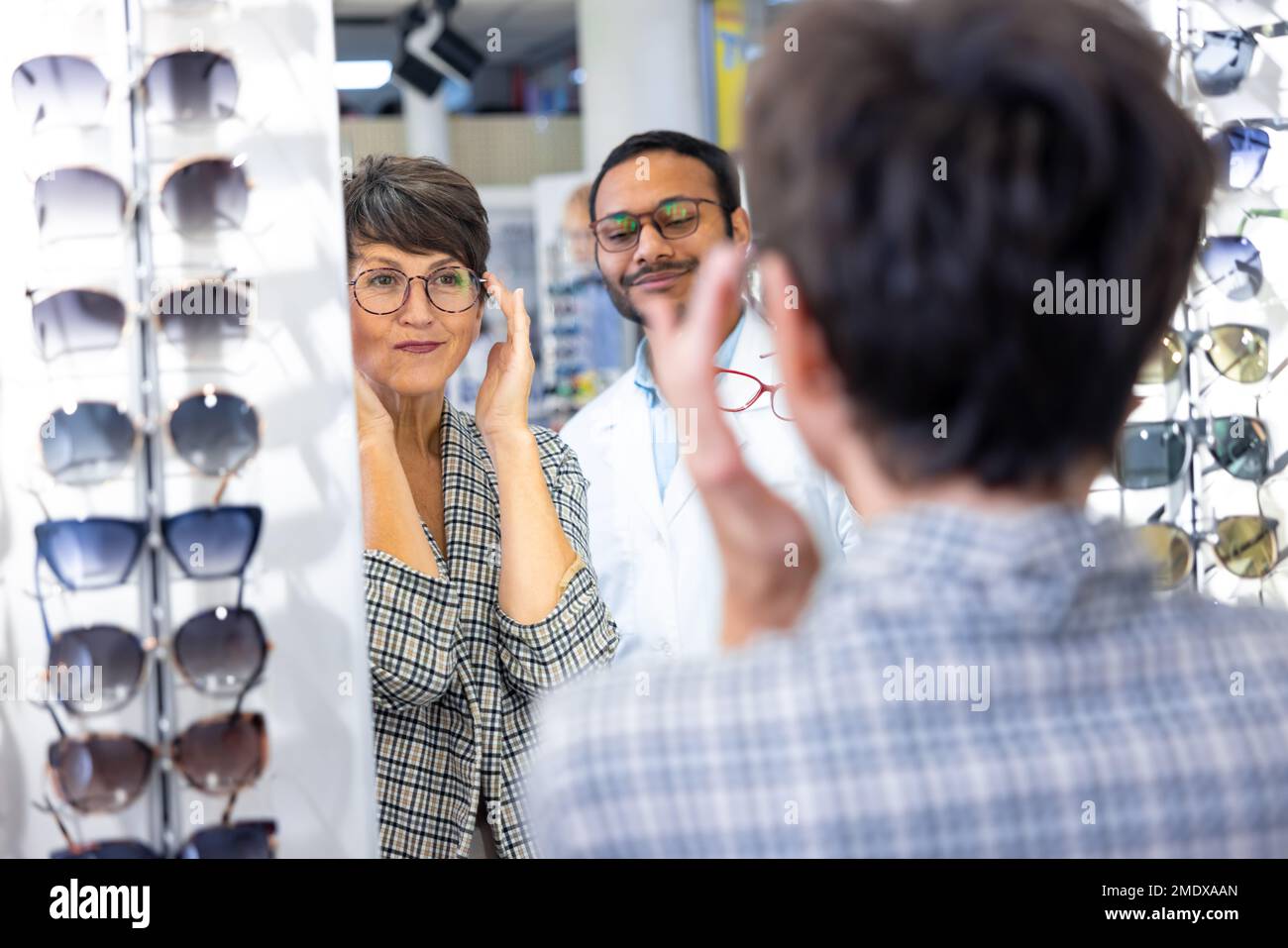 Male optometrist helpting a woman to choose eyeglasses Stock Photo - Alamy