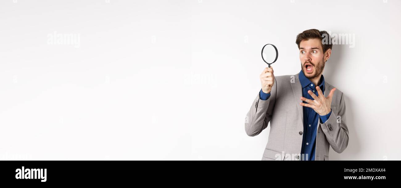 Shocked guy look through mafnifying glass with startled face, gasping ...
