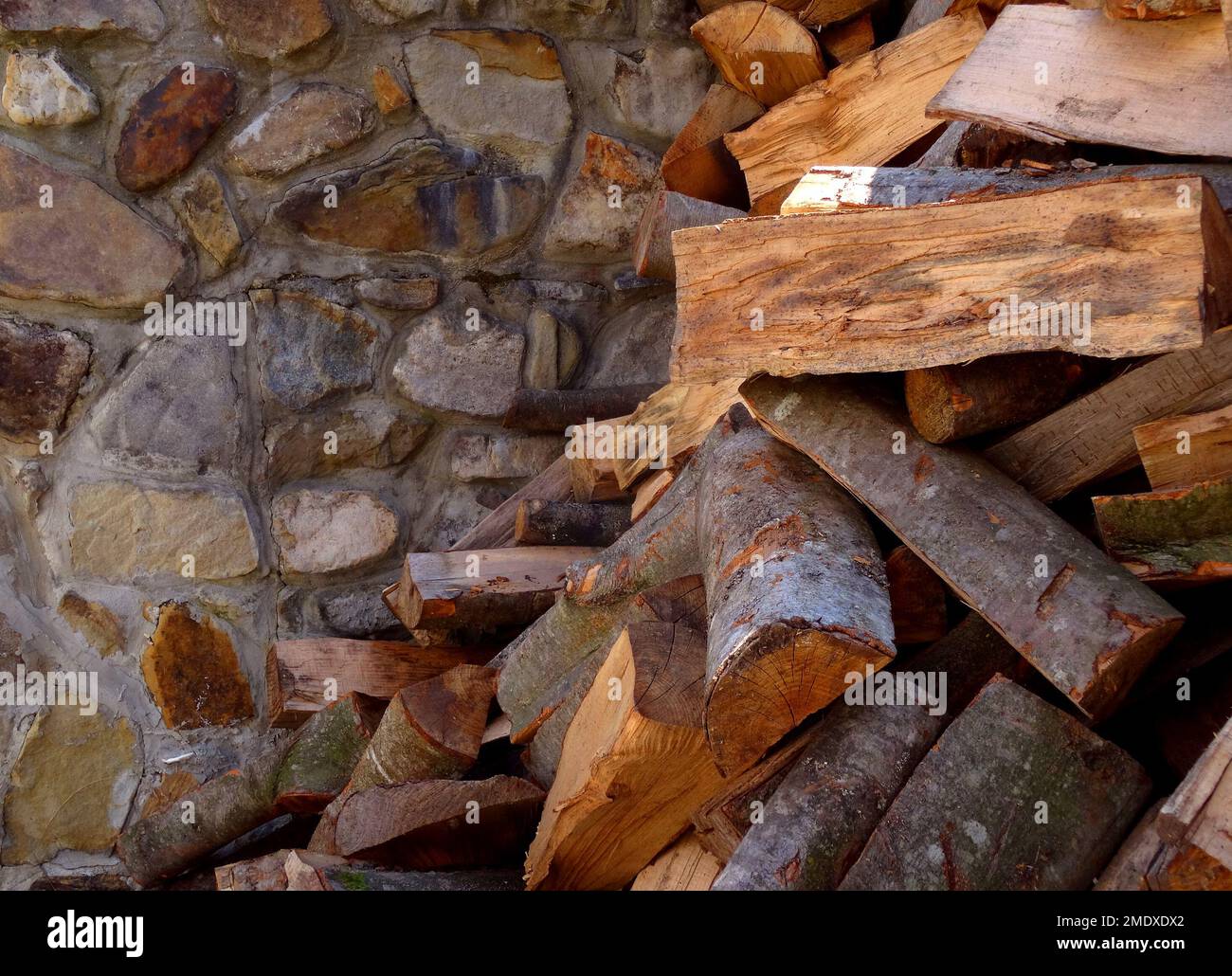 Chopped Wood Logs For Stove Near Rock Wall Stock Photo - Alamy