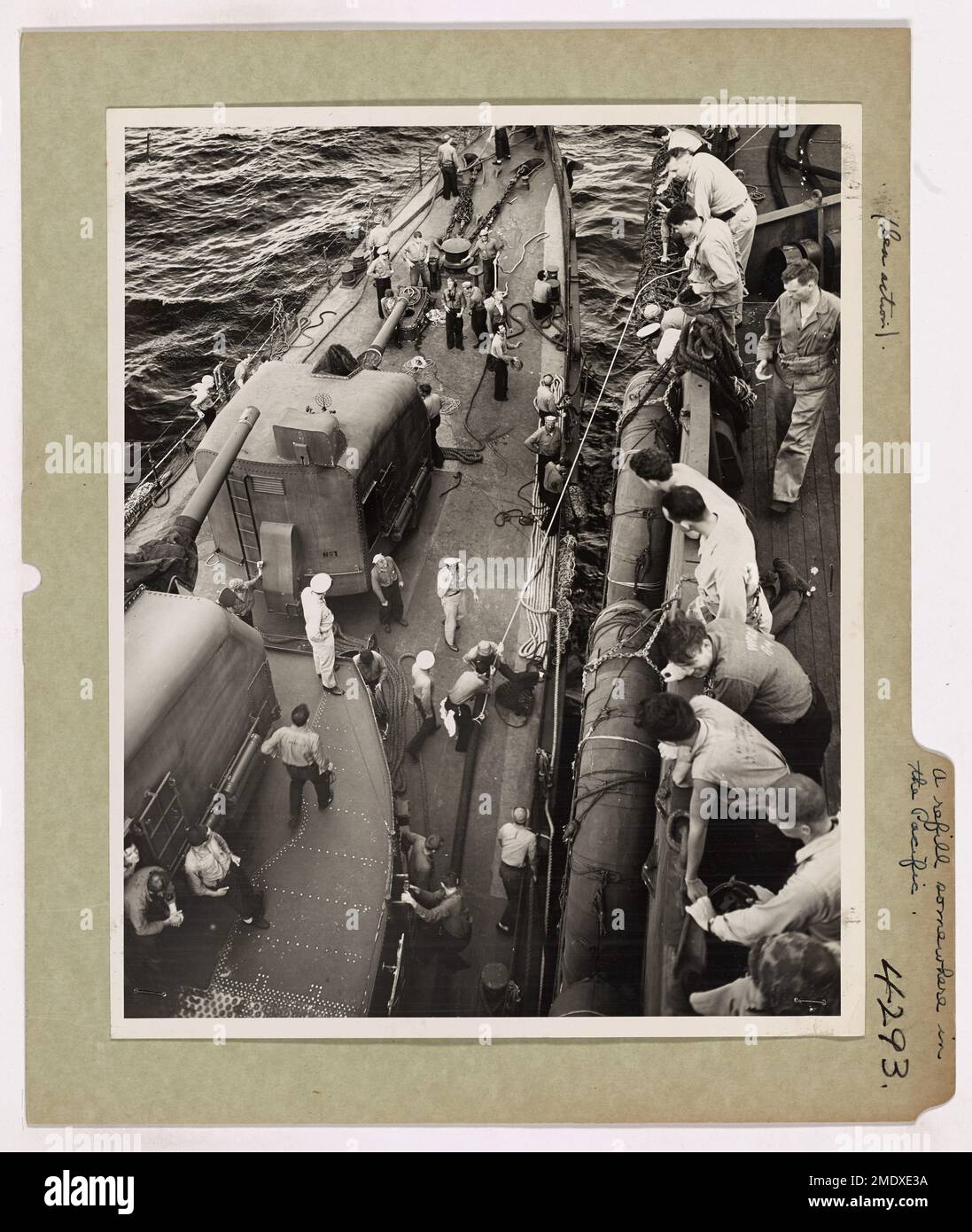 A Coast Guard-manned assault transport ties up to a Navy destroyer for ...