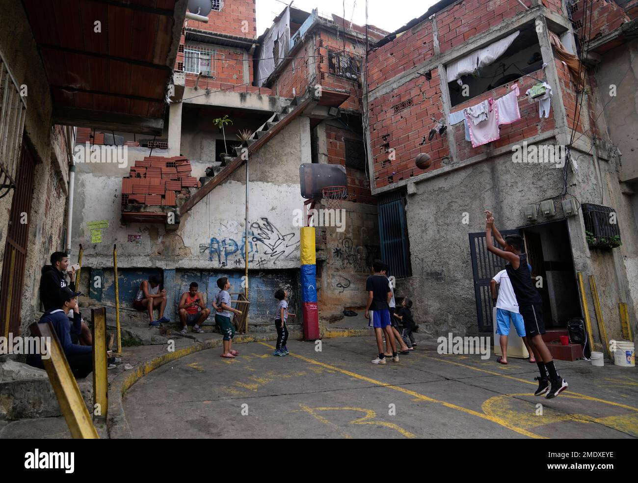 People play basketball in the Catia neighborhood of Caracas, Venezuela ...