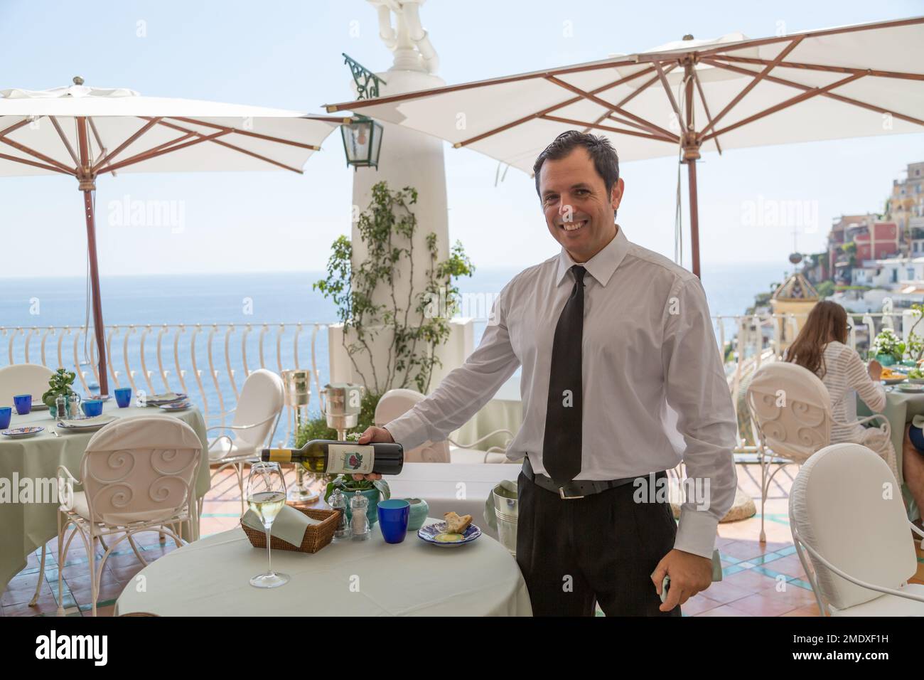 Waiter pouring wine at Michelin restaurant La Sponda at the luxury Le ...