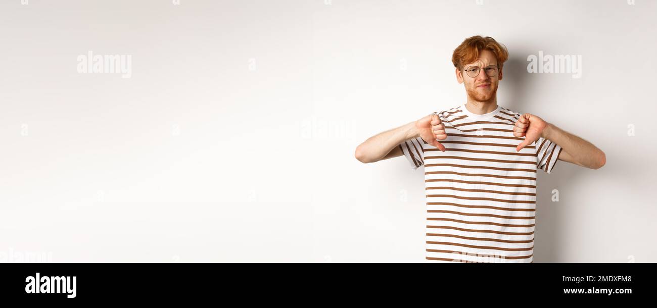 Disappointed young man with red hair and glasses disagree, showing ...