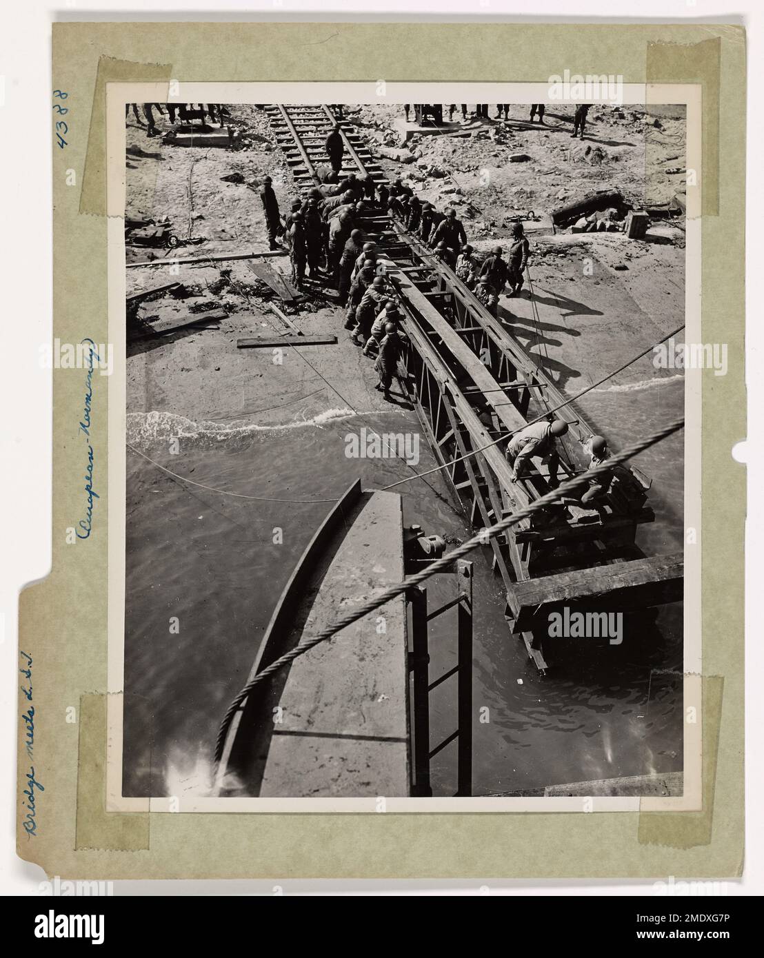 Soldiers deploy a railed bridge to connect a railroad in France to a ...