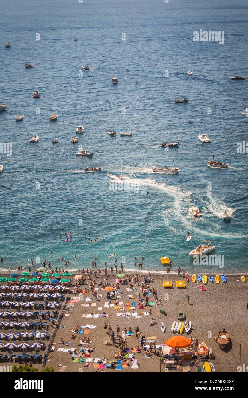 View of sunbathers and swimmers on the beach and in the sea in Positano ...