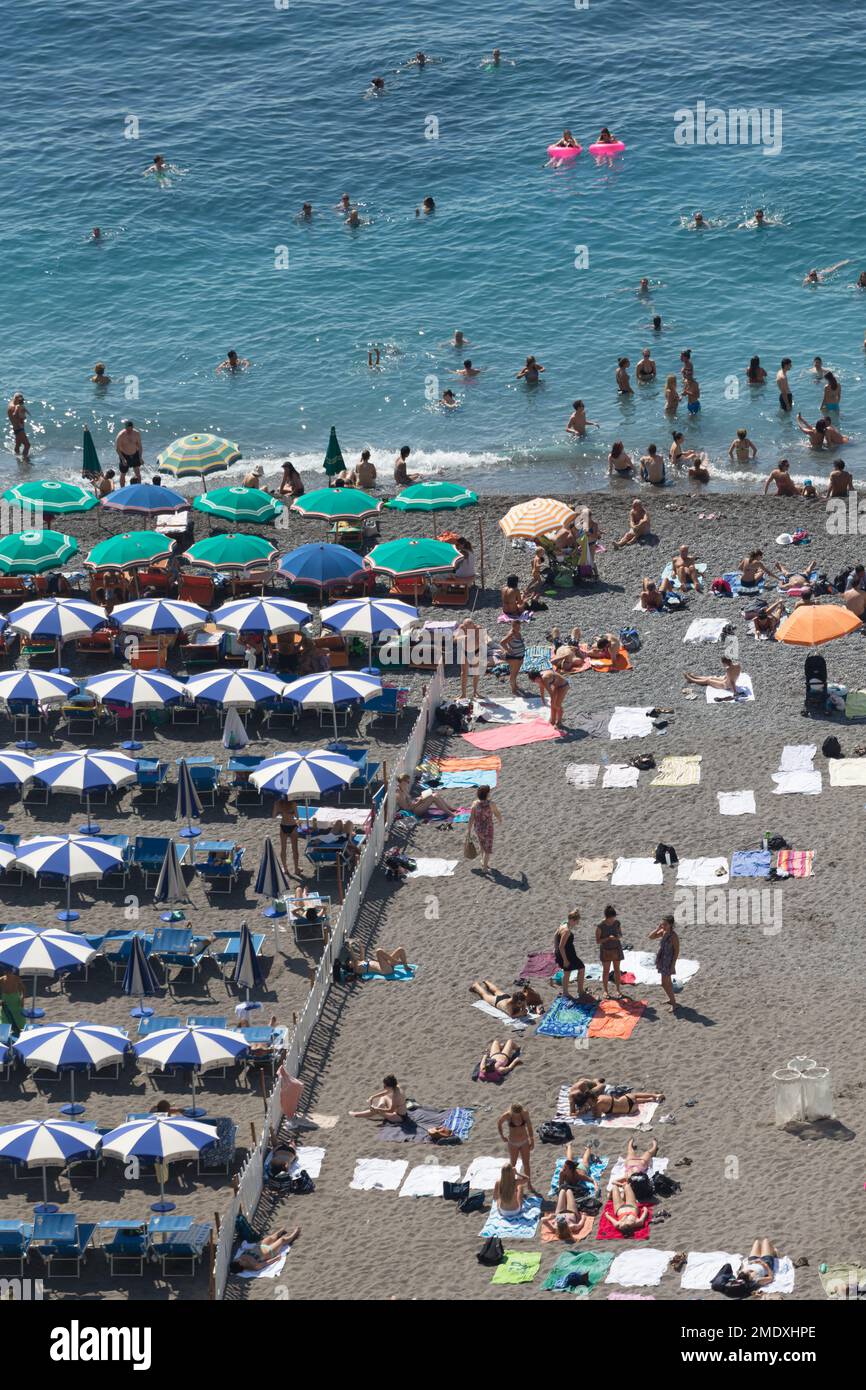 View of sunbathers and swimmers on beach and in the Sea in Positano ...