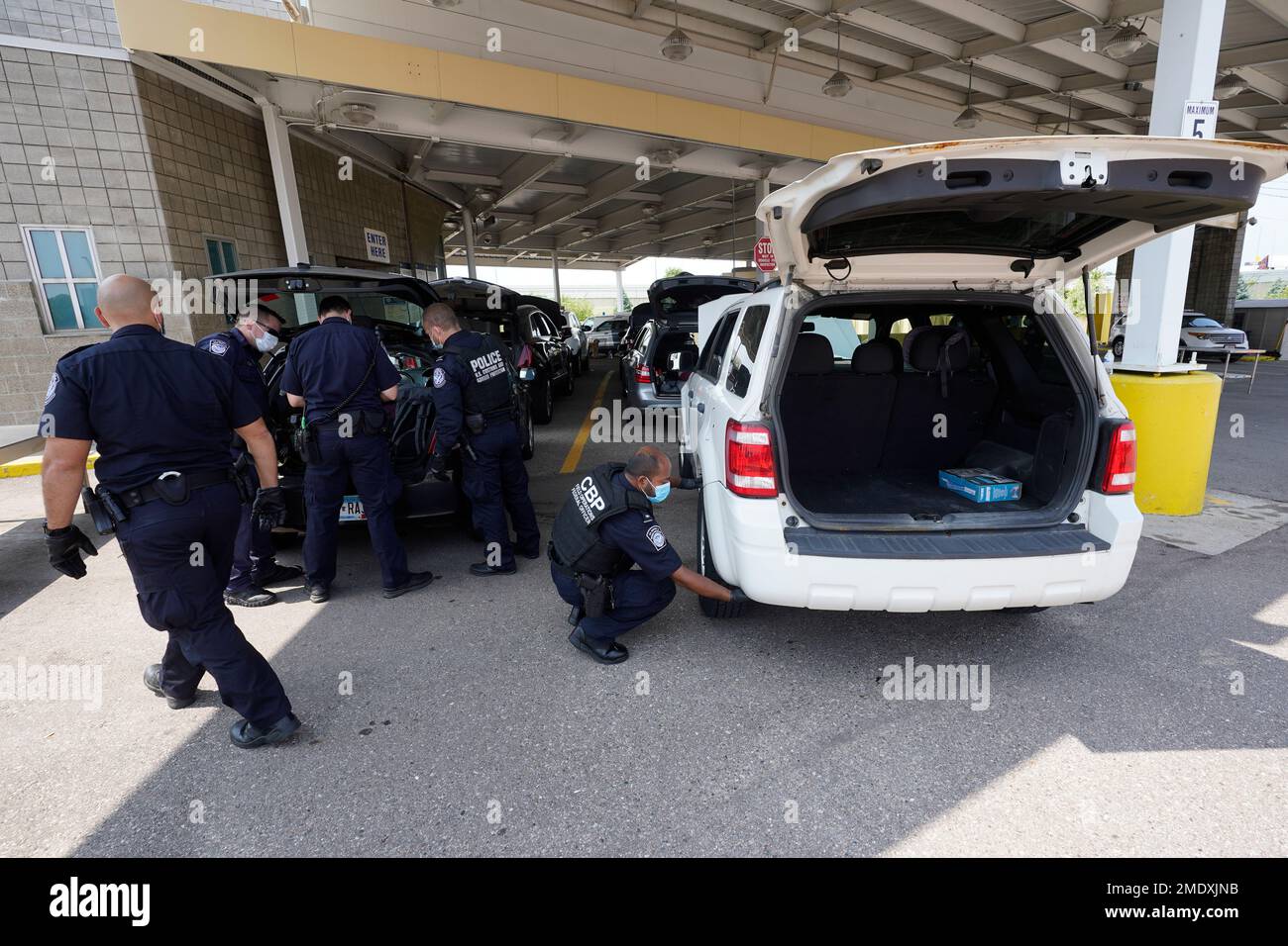 U.S. Customs and Border Protection agents search vehicles entering the ...
