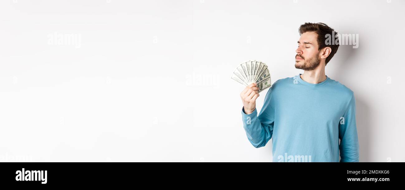 Handsome rich man with beard looking at money, got quick loan, standing ...